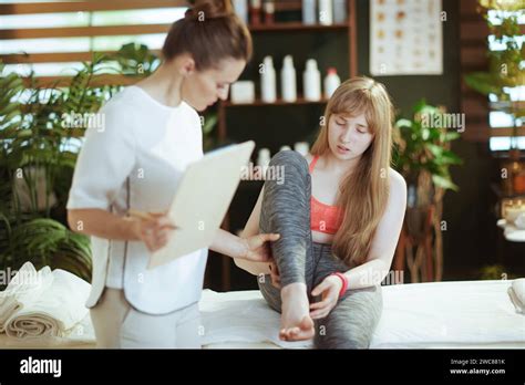 Healthcare Time Concerned Massage Therapist Woman In Massage Cabinet