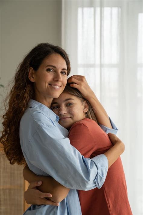 Feliz Madre E Hija Adolescente Abrazando Y Sonriendo A La C Mara Vinculaci N Familiar Foto De