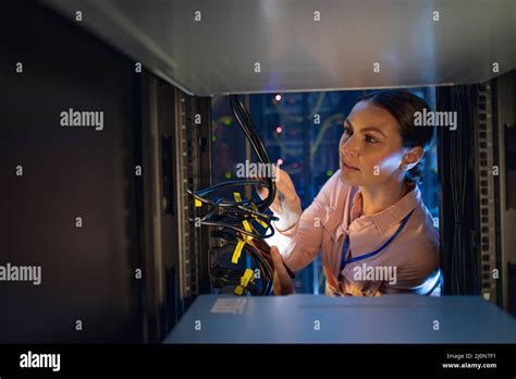 caucasian female engineer inspecting the server in computer server room