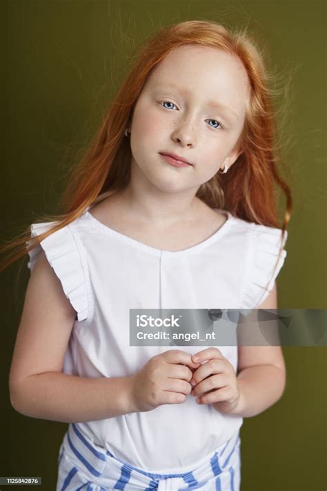 긴 머리와 아름 다운 큰 파란 눈을 가진 아름 다운 빨간 머리 소녀 올리브 색상의 배경에 포즈 여름 옷에 빨간 머리 여자 아이 밝은 붉은 머리를 가진 노르웨이 여자 건강한