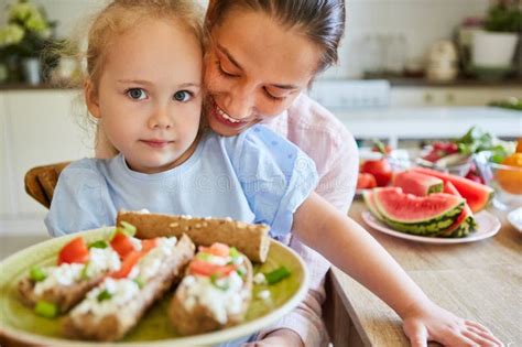 Madre Abrazando A Su Hija Sosteniendo El Plato De Bruschetta Imagen De