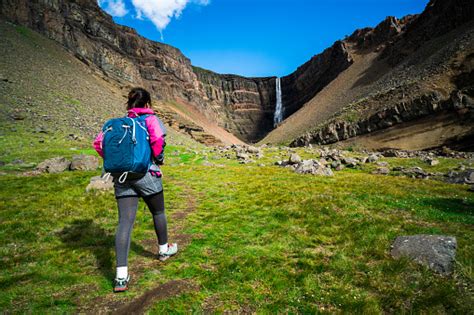 아이슬란드에 있는 헨 기 폭포에서 아이슬란드의 여름 풍경 속에서 즐기는 여성 여행자 트레킹 폭포는 아이슬란드의 동쪽에 위치 하 고 있습니다 경관에 대한 스톡 사진 및 기타