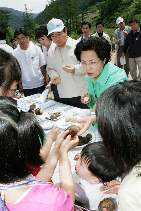 노무현사료관 [농산촌 관광마을 방문 중 어린이들에게 감자를 건네는 권양숙 여사]
