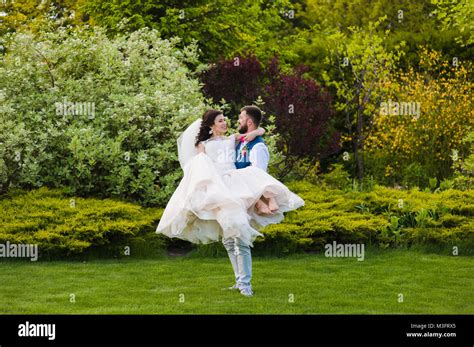 Happy Couple Outdoors Barefoot Woman In Man Hands During Their Wedding