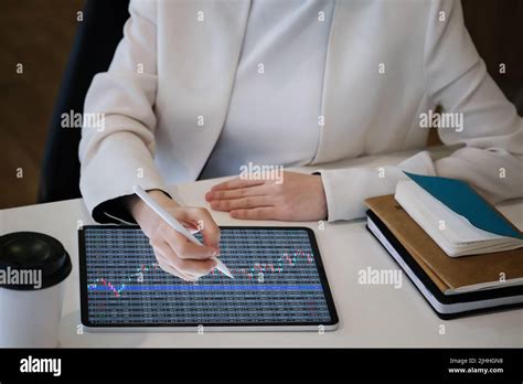 Business Woman Using Tablet To Trade Charts To Find Buy And Sell Points