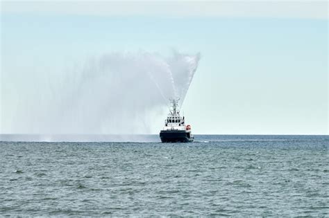 Premium Photo Fireboat Ship Sails On Open Sea Directing Jets Of Water