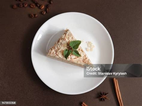 갈색 배경에 민트가 있는 크림 나폴레옹이 있는 레이어드 케이크의 상위 뷰 계피 스틱 Badyan 갈색 배경에 커피 콩 복사 공간