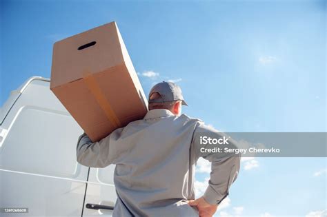 밴의 배경에 골판지 상자를 들고 손에 회색 양복을 입은 남자 우편 배달의 주제에 대한 개념 30 34세에 대한 스톡 사진 및 기타 이미지 Istock
