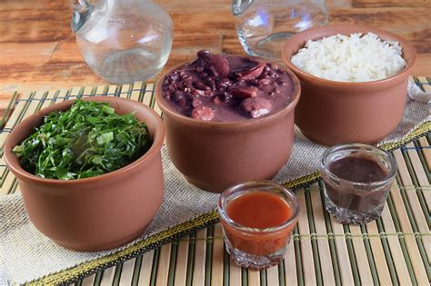 Feijoada 전형적인 브라질 음식 돼지 고기 베이컨을 곁들인 콩 오렌지 쌀과 밀가루 칠리 소스 및 크래클링 Farofa에