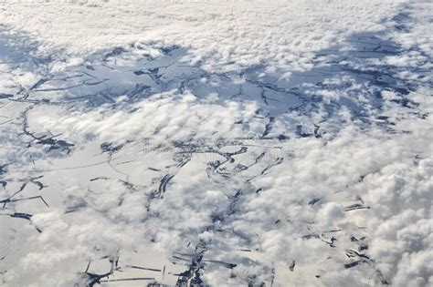 Aerial View Over Clouds Top To Snow Covered Rivers, Fields and Roads ...