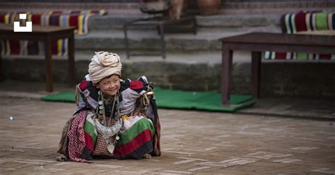 회색과 여러 가지 빛깔의 드레스를 입은 유아가 바닥에 무릎을 꿇고 흰색을 구부리고 사진 사진 Unsplash의 무료 박타푸르 이미지