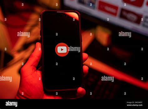 Man Holding IPhone 14 Pro Max Smartphone With Youtube App In Front Of