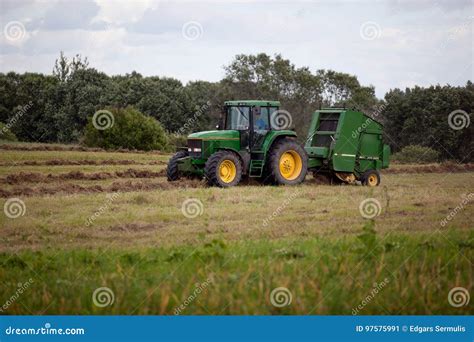 Latvia August 62017 John Deere Tractor Collecting Hay Of Dry Grass