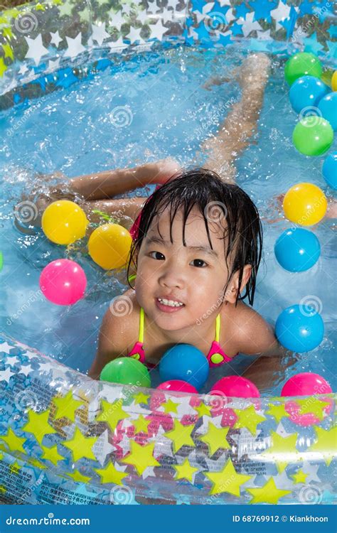 Asian Little Chinese Girl Playing In An Inflatable Rubber Swimming Pool