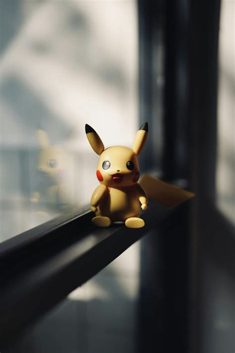 A Toy Pikachu Sitting On A Window Sill Photo Free Pikachu Image On