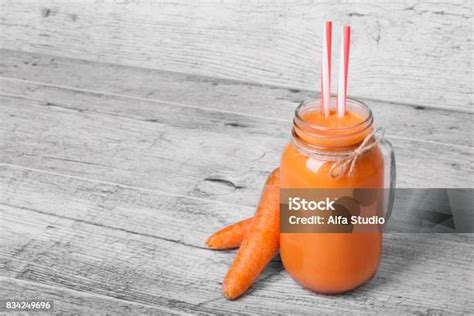 신선한 당근 주스 빨 대와 회색 나무 테이블에 한 병에서 전체 당근 당근와 주스의 메이슨 항아리입니다 0명에 대한 스톡 사진 및 기타 이미지 Istock
