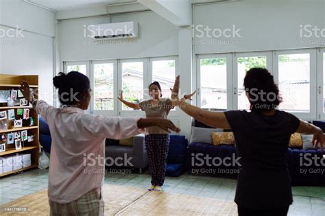 A Young Asian Women Teaches A Community Dance Class To Senior Citizens