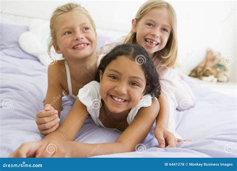 Tres Chicas Jóvenes Que Mienten Encima De Uno a Foto de archivo Imagen de teniendo muchachas