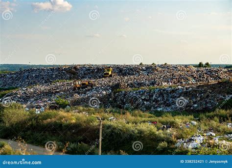 the landscape shows a sprawling landfill with heavy machinery working