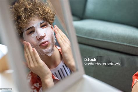 Junger Schwuler Mann Trägt In Einem Wohnzimmer Eine Gesichtsmaske Auf