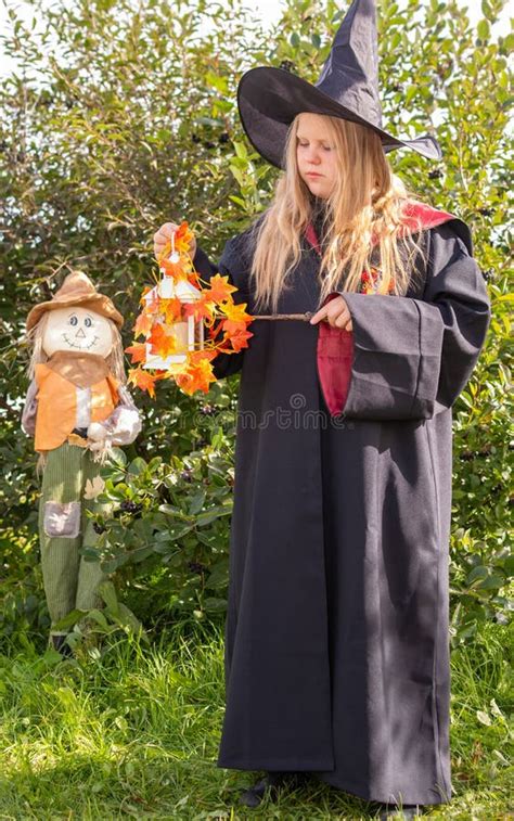 Halloween A Girl In A Robe And Hat A Little Sorceress In The Costume