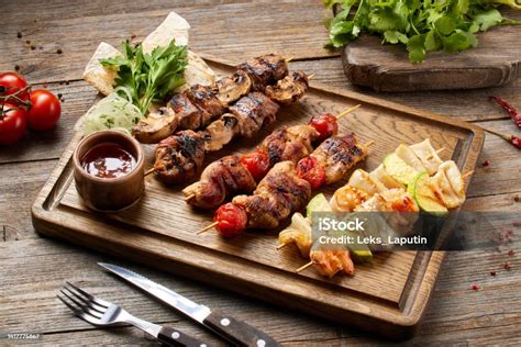라바시 소스와 허브가있는 나무 보드의 테이블에 닭 버섯과 해산물의 Shish 케밥 세트 개체 그룹에 대한 스톡 사진 및 기타