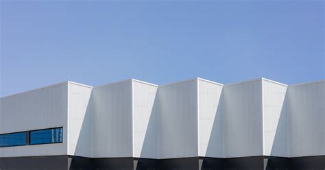 공장 산업 기하학적 인 현대적인 디자인의 창고 건설 푸른 하늘 배경에 알루미늄 외관이있는 건축 건물 배경 벽 금속 골판지 강철 표면 패턴 사진 Unsplash의
