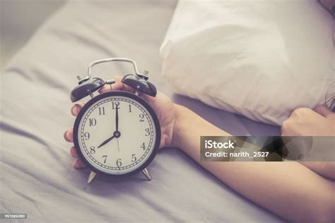 근접 촬영 아시아 젊은 여 자가 좋은 아침에 알람 시계를 해제 알람 시계 시간과 라이프 스타일 개념을 들고 여자와 수 면에 대