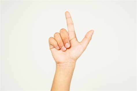 白い背景に隔離された平和のサインを示す2本の指で指を指している子供の手 Premium写真
