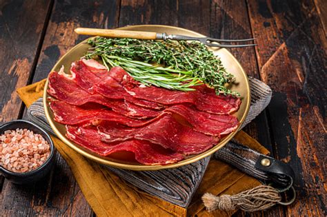 Basturma 얇게 썬 말린 쇠고기 고기 허브와 향신료가있는 강판에 고기 Jerky 나무 배경 위쪽 보기 파스트르마에 대한