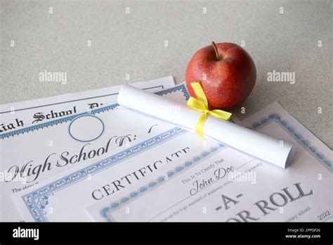 A Honor Roll Recognition Certificate Of Achievement And High School Diploma Lies On Table With