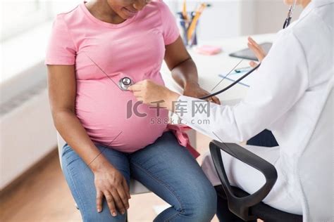 怀孕医学医疗保健和人的概念 关闭妇科医生用听诊器在医院听怀孕的非洲裔美国妇女婴儿心跳高清摄影大图 千库网