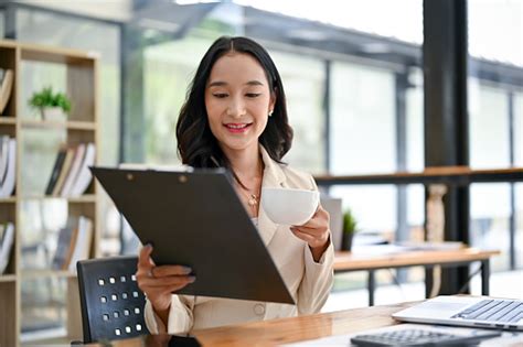 비즈니스 보고서를 검토하고 책상에서 커피를 홀짝이는 아름다운 아시아 여성 사업가 30 34세에 대한 스톡 사진 및 기타 이미지 30 34세 검사 보기 경영자 Istock