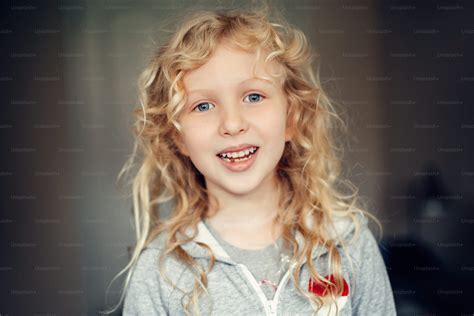 긴 지저분한 머리를 가진 아름다운 미소 백인 금발 소녀의 근접 촬영 초상화 자연스러운 감정을 가진 예쁜 진짜 여자 아이 행복한 정통 어린 시절 라이프 스타일 잃어버린