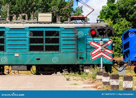 Red Signal Of Semaphore And Stop Sign In Front Of Railroad Crossing With Train Passing Royalty