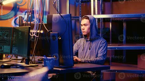 Hacker In Graffiti Painted Underground Bunker Discussing With Colleague About Best Approach For