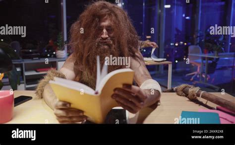 In Modern Office Savage Caveman Reading A Journal Screaming And Yelling