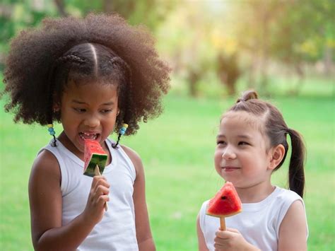 Premium Photo Cute Girls Eating Watermelon Outdoors