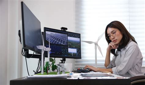 안경을 쓴 여성 엔지니어는 개인용 컴퓨터에서 자신의 프로젝트에 대해 생각하고 노트북에서 디지털 프로그램의 레이아웃을 측정하고 사무실이나 공동 작업 공간에 앉아 풍력 터빈