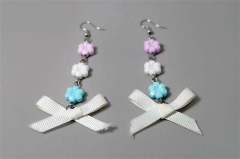 샹들리에 귀걸이 평면도를 위한 아름 다운 리본 나비 귀걸이 패션 액세서리 어떤 사용에 대 한 좋은 회색 배경에 고립 된 파스텔 꽃 구슬 귀걸이의 쌍 0명에 대한 스톡 사진