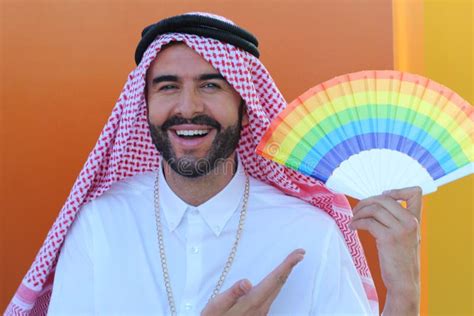 Proud Arabic Gay Man Holding A Fan With The Rainbow Flag Stock Image