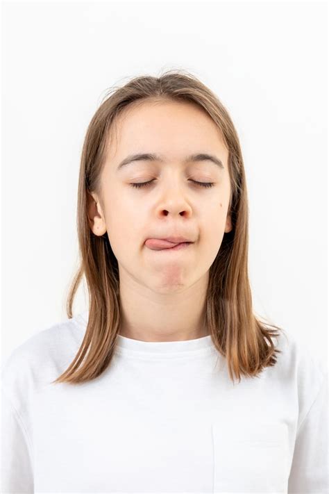 Free Photo Funny Teenage Girl Licks Her Lips On A White Background