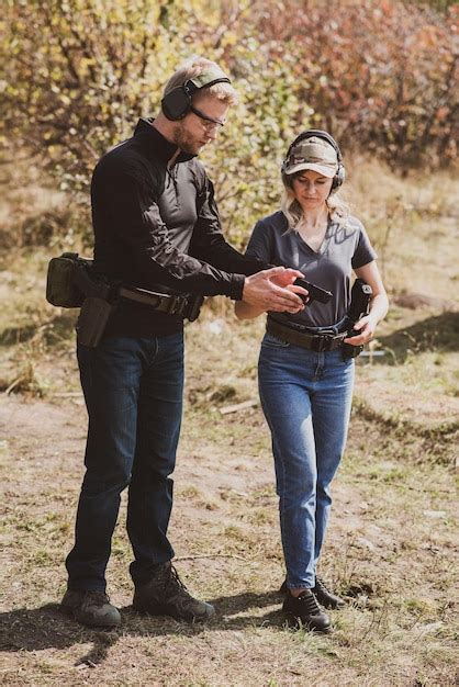 Premium Photo Shooting Instructor Teaching A Woman How To Properly Handle A Weapon At The