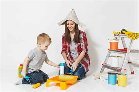 엄마와 재건축 아파트 룸 흰색 배경에 고립에 대 한 장비와 작은 아들 벽지 액세서리를 붙이기 그림 도구 소년 여자 집 수리입니다 부모 어린 시절 개념입니다 개선에 대한 스톡