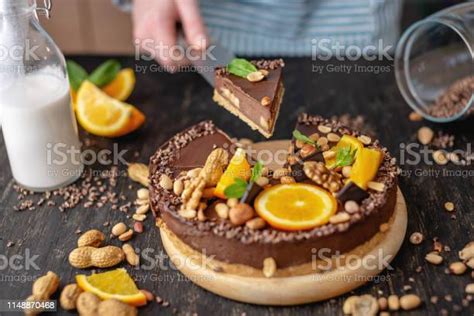 과자 요리사는 오렌지 민트와 견과류와 초콜릿 케이크의 조각을 들고 손에 채식주의자를 위한 건강 한 생 디저트 과일에 대한 스톡 사진 및 기타 이미지 Istock