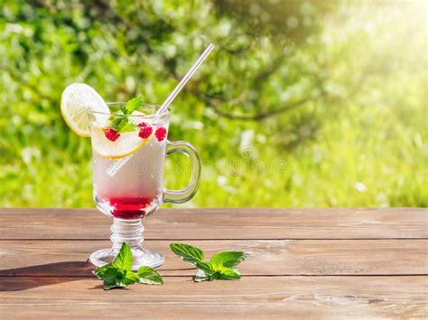 Refreshing Summer Cocktail With Lemon Raspberry And Mint A Wooden