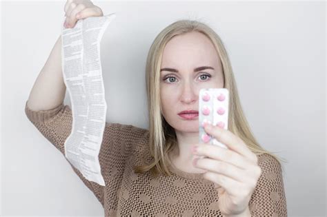 那個白底的女孩讀著藥品的說明書那個女人看著藥物的清單和成分家庭自用藥物的概念和藥物性質的研究 照片檔及更多 人 照片 人 健保和醫療