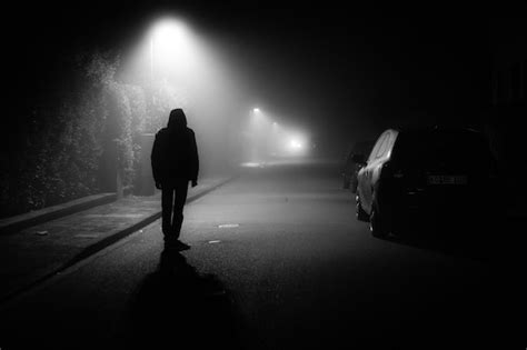 Premium Photo Grayscale Silhouette Of A Man With Hoody Walking In A