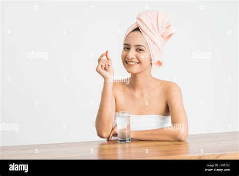 Young Asian Beauty Young Woman Eating Pills And Drinking Water On White