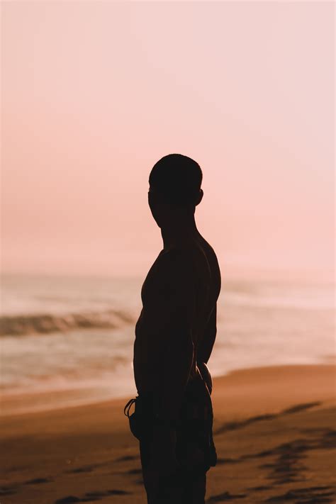 Foto Silueta De Hombre Estar De Pie En Playa Durante Ocaso